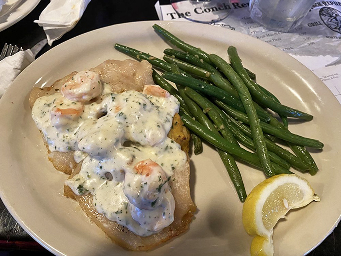 Seafood draped in creamy sauce that would make Neptune himself request seconds. Those green beans aren't just a garnish—they're the supporting actors in this delicious drama.