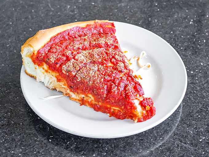 The cross-section of stuffed pizza reveals layers of deliciousness that would make geologists weep with joy. Cheese archaeology at its finest.