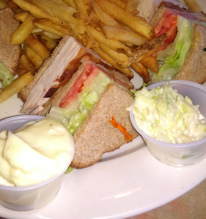 A proper club sandwich isn't just stacked&mdash;it's architecturally sound, with perfect proportions of turkey, bacon, and fresh vegetables, flanked by crispy fries.