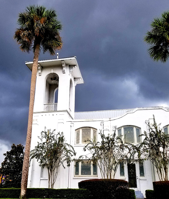 Storm clouds gather dramatically over this pristine white church, proving that even Florida's temperamental weather adds character to DeLand's architectural treasures.
