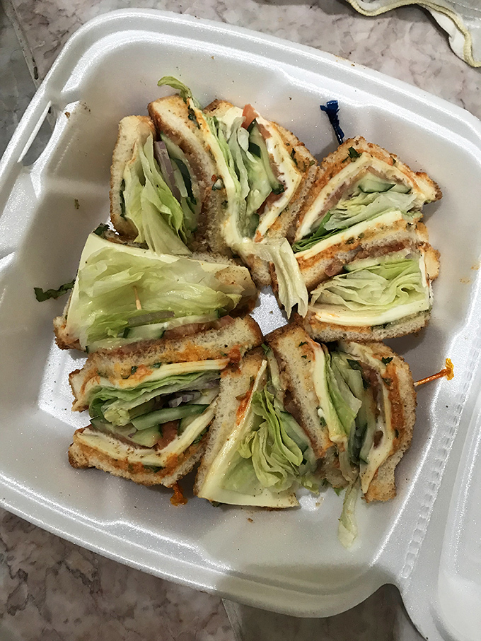 Club sandwiches cut into perfect triangles remind us that presentation matters, even for comfort food classics.