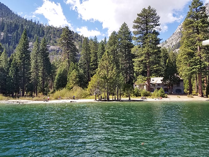 Beach day, mountain style. Vikingsholm's shoreline offers a sandy respite where pine-scented breezes replace the typical coconut sunscreen aroma.