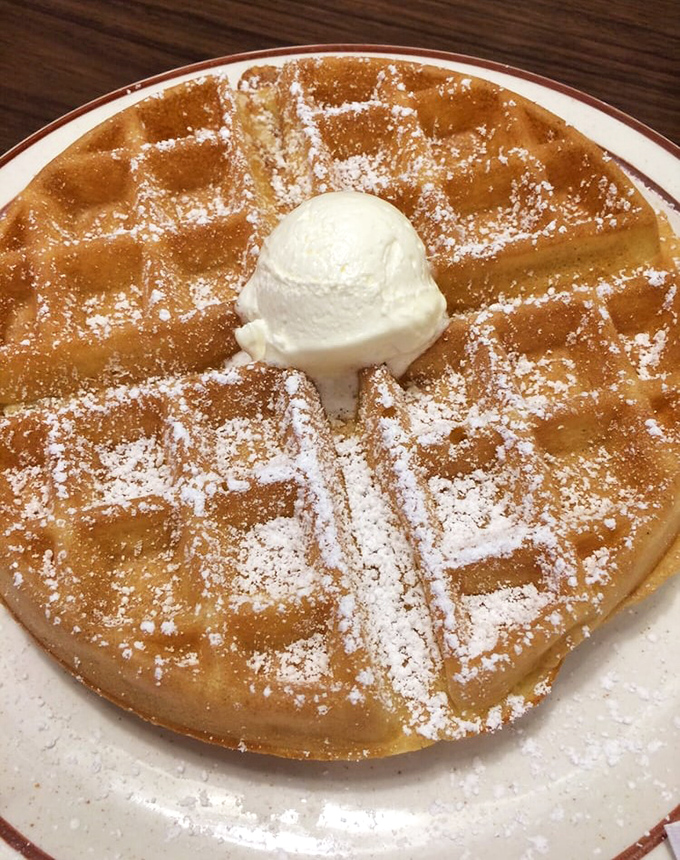 The Belgian waffle that launched a thousand return visits. That perfect golden grid with its powdered sugar dusting is breakfast architecture at its finest.