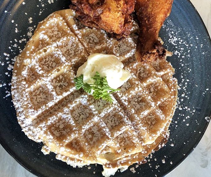 The waffle doesn't just share a plate with chicken&mdash;it elevates the entire experience. That dusting of powdered sugar is like snowfall in comfort food heaven.