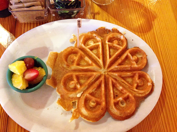 That waffle isn't just shaped like a flower – it's breakfast architecture, designed to hold perfect pools of maple syrup in each golden pocket.