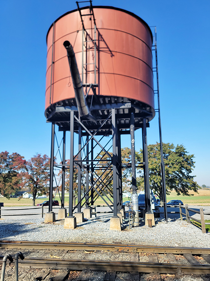 The railroad's water tower stands sentinel against the autumn sky, a rust-colored giant that's quenched the thirst of countless iron horses.