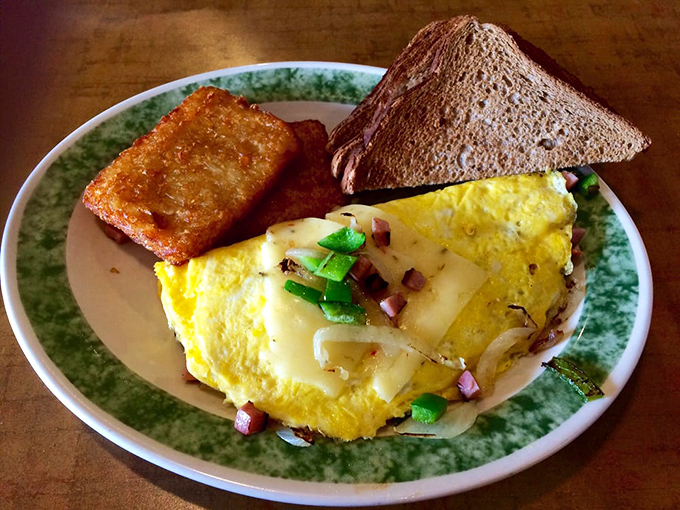 An omelet that knows its purpose in life: to deliver cheese, veggies, and breakfast satisfaction while keeping perfect company with golden hash browns.