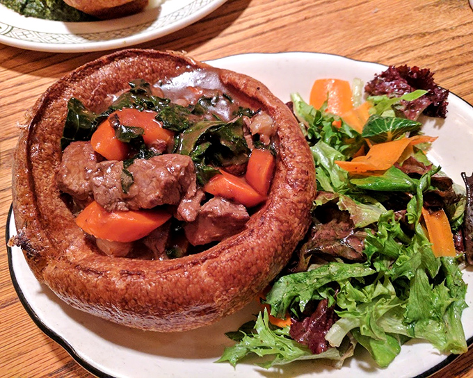 Toad in the hole—where sausages nestle in Yorkshire pudding like meaty treasures in a golden chest, ready to transport you across the Atlantic.