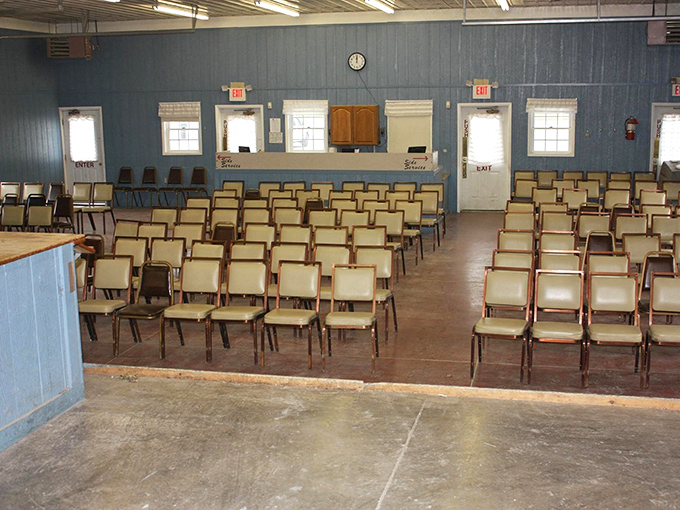The auction hall sits in quiet anticipation before the rapid-fire bidding begins. These unassuming chairs will soon hold competitive bidders clutching numbered cards and poker faces.