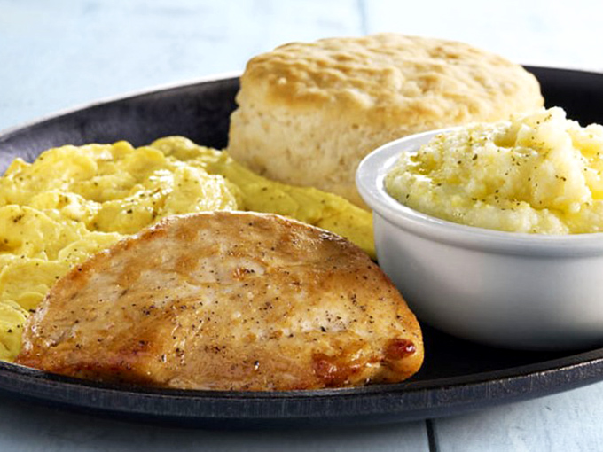 A perfect Southern breakfast trinity: golden biscuit, savory country ham, and creamy grits that would make any grandmother nod in approval.