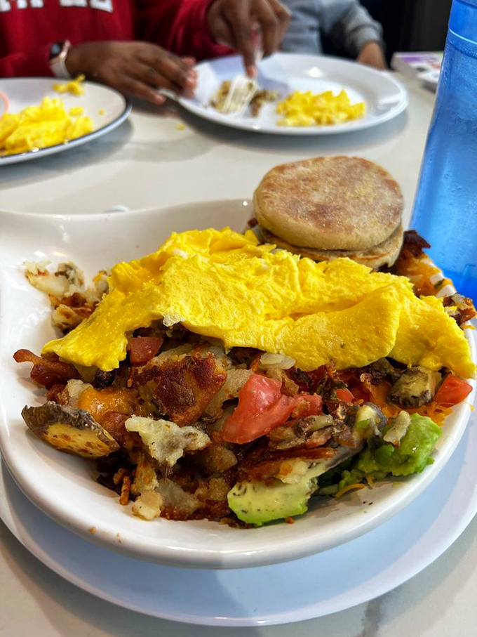 Breakfast architecture at its finest—layers of potatoes, vegetables, and eggs creating a skillet masterpiece that demands to be demolished.