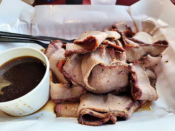 Brisket sliced so thin you could read the sports page through it, with a smoke ring that deserves its own championship belt.