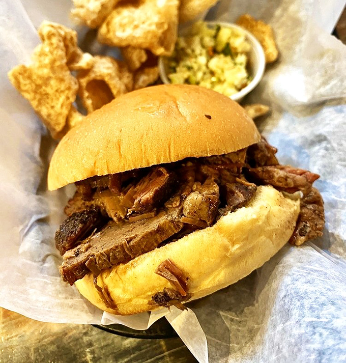 The pulled pork sandwich &ndash; barbecue in its most honest form. Tender strands of smoke-infused pork on a simple bun, with crispy skin cracklins that shatter like porcine candy.