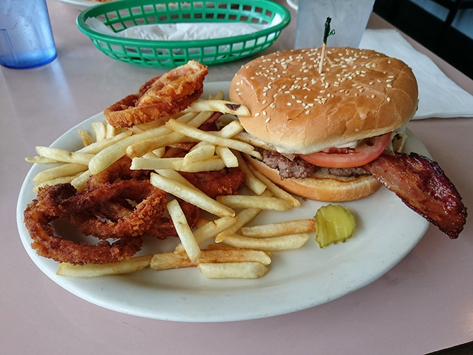 Burgers should require both hands and at least three napkins. This beauty, with those golden onion rings standing guard, understands the assignment perfectly.