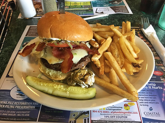 This isn't just a burger—it's an architectural marvel with bacon, cheese, and veggies stacked higher than your weekend expectations.