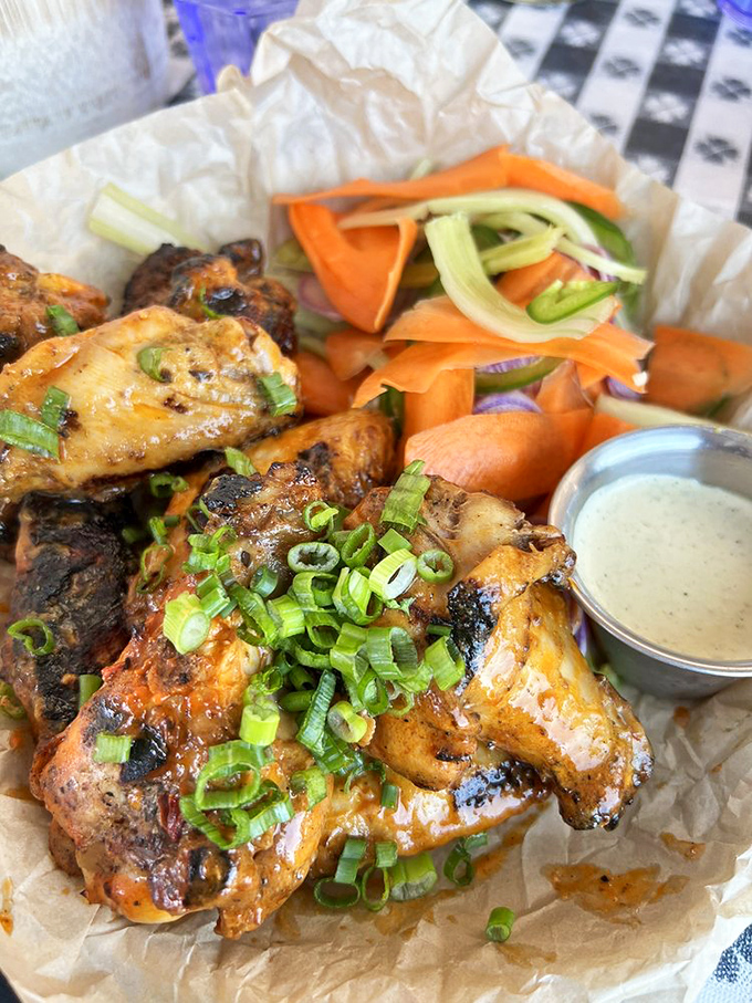 Buffalo wings with enough char to make a backyard grill master jealous, served with the kind of fresh vegetables that make you feel virtuous while devouring fried chicken.