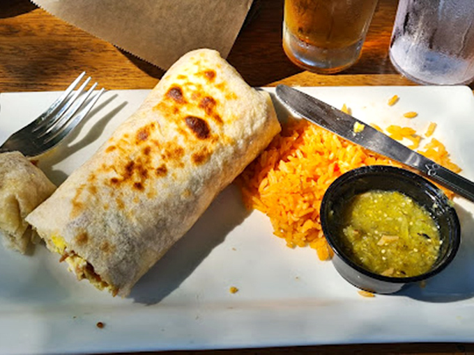 This burrito isn't just wrapped—it's embraced. Golden-brown perfection flanked by Spanish rice that didn't come from a box, thank goodness.