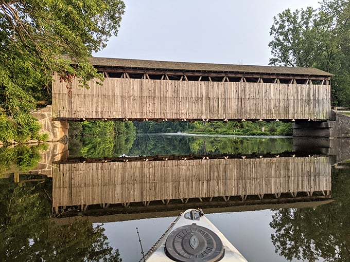 Mirror, mirror on the river. The bridge's perfect reflection creates a wooden infinity symbol, connecting past and present in crystalline waters.
