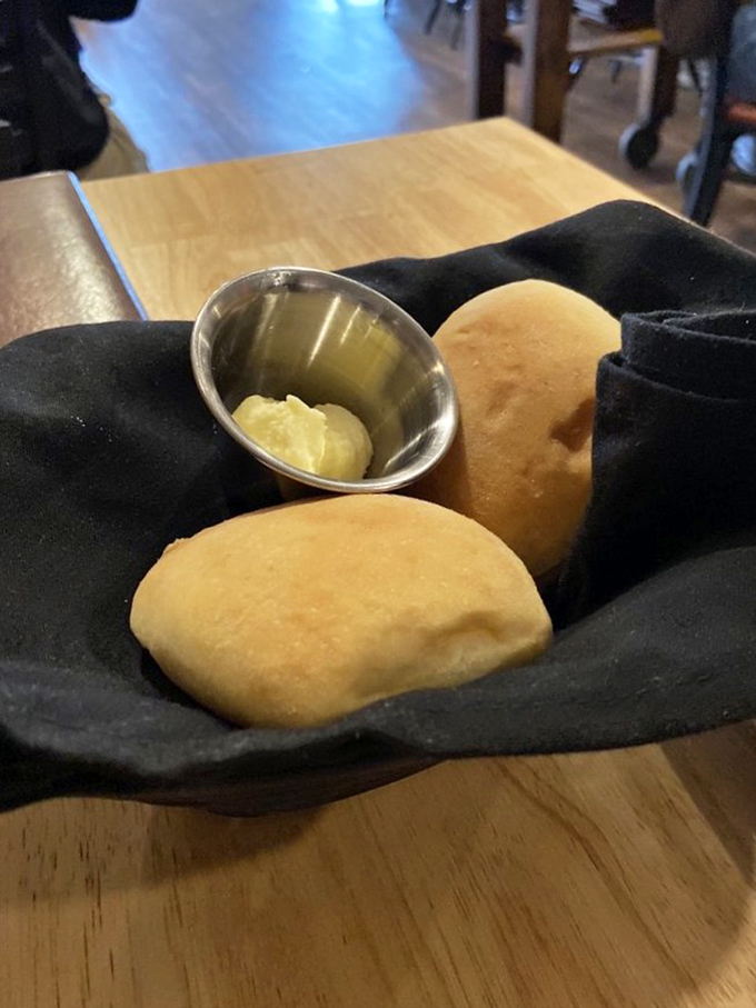 Warm rolls nestled in their cozy black napkin blanket, with butter standing by for its supporting role. The opening act that sets the stage for greatness.