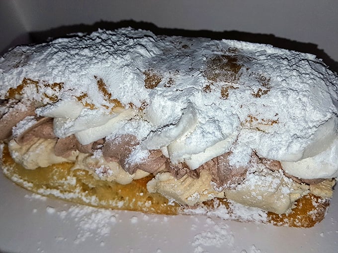 Beneath that mountain of powdered sugar lies a cream-filled masterpiece that makes grocery store donuts hang their heads in shame.