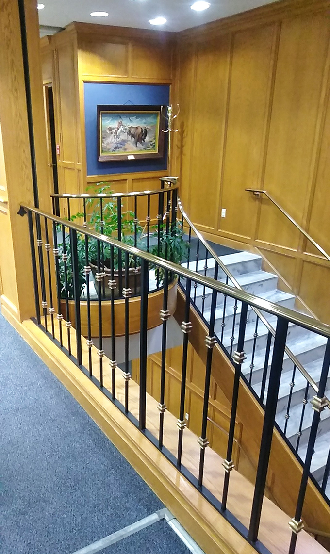 Elegant wooden paneling and wrought iron railings guide visitors between floors. This staircase has probably witnessed more literary journeys than physical ones.