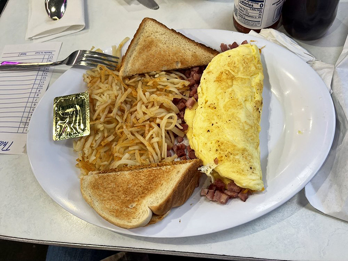 The Western omelet&mdash;a golden envelope of eggs stuffed with ham and perfectly melted cheese&mdash;flanked by crispy hash browns and toast soldiers ready for action.