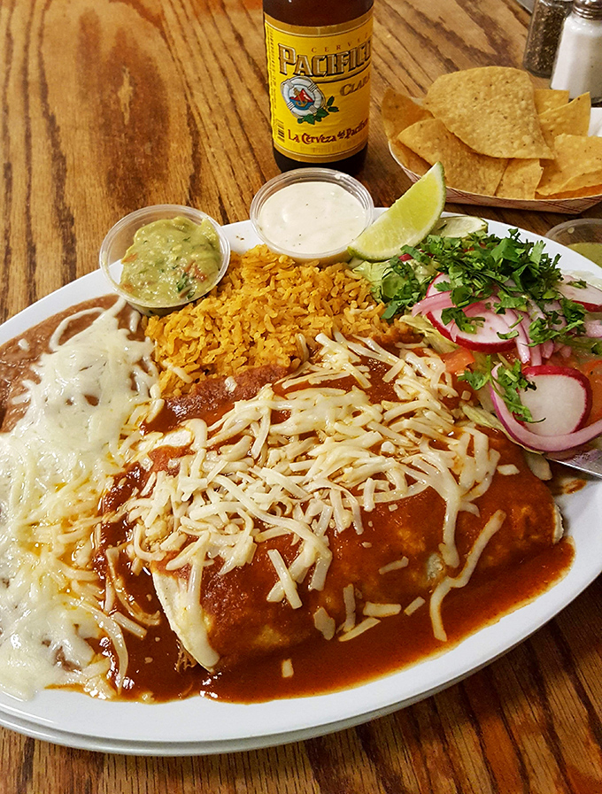 Enchiladas smothered in sauce and cheese, paired with a cold Pacifico&mdash;proof that sometimes the simplest pleasures are the most profound.