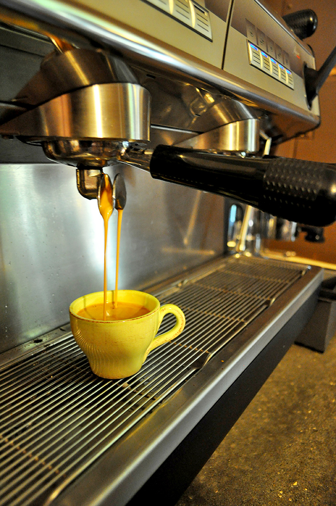 Espresso flowing like liquid gold into a sunny yellow cup. This isn't just coffee&mdash;it's morning salvation crafted with mechanical precision and artistic soul.