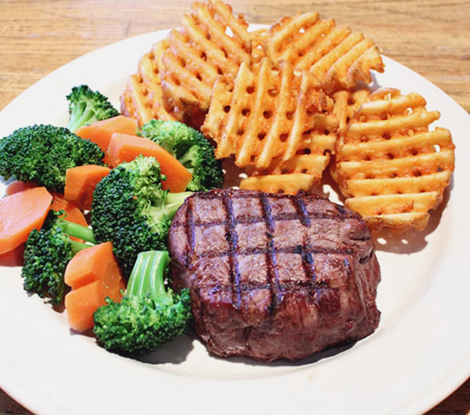 Who needs fancy steakhouse theatrics when you can get a perfectly grilled filet, waffle fries, and fresh veggies without the second mortgage?