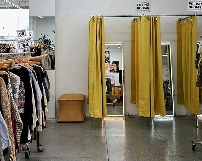 Fitting rooms with mustard-yellow curtains offer just enough privacy to transform from curious browser to triumphant purchaser.