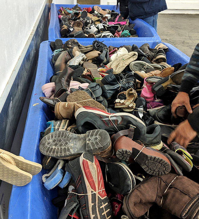 A footwear archaeologist's dream dig site. Somewhere in this blue bin of possibility lies the perfect pair of barely-worn hiking boots.