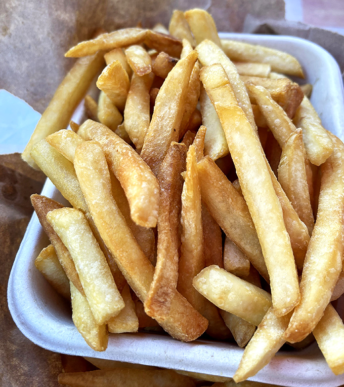 These aren't just French fries; they're golden happiness sticks that somehow manage to stay crispy on the outside, fluffy inside—a potato's highest calling.