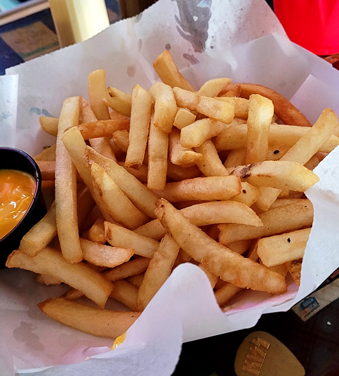 French fries so perfectly golden and crisp they deserve their own fan club. That little cup of cheese sauce is about to experience a very brief existence.