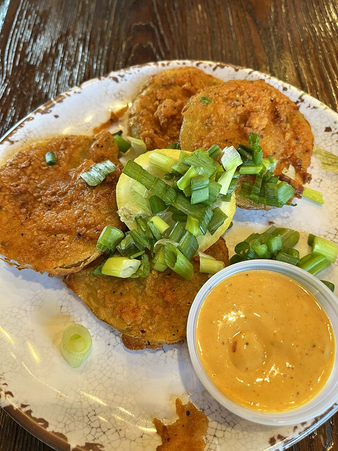 Fried green tomatoes: the South's gift to the culinary world. Crispy, tangy discs of joy with a sauce that makes you want to lick the plate when nobody's looking.