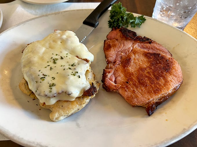 A perfect marriage on a plate: juicy pork chop meets chicken smothered in melted cheese &ndash; proof that sometimes the simplest combinations yield the greatest pleasure.