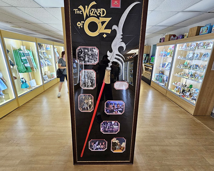 A corridor of illuminated treasures stretches before you, each cabinet a window into different dimensions of Oz lore.