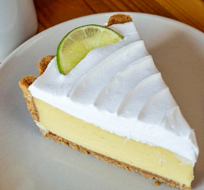 Key lime pie that strikes the perfect balance between tart and sweet, topped with a cloud of whipped cream and a lime slice exclamation point.
