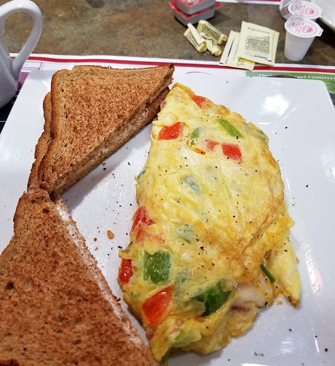 An omelet bursting with vegetables like a garden party decided to throw itself onto your breakfast plate &ndash; pure morning joy.