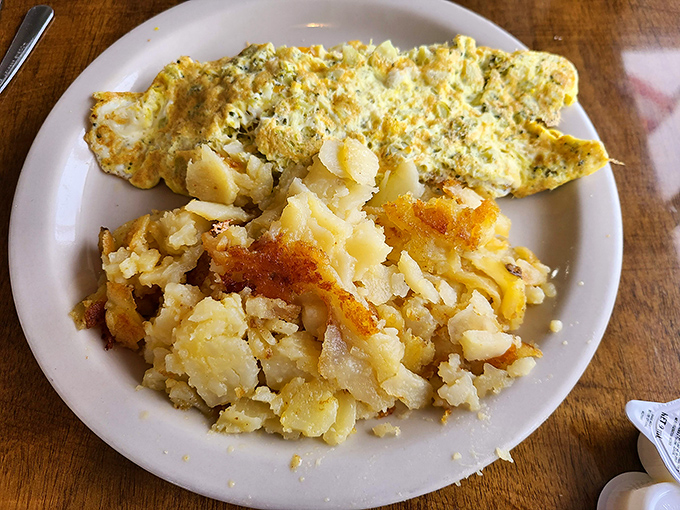 The holy trinity of breakfast: a herb-flecked omelet, crispy-edged home fries, and the promise that your day is starting off absolutely right.