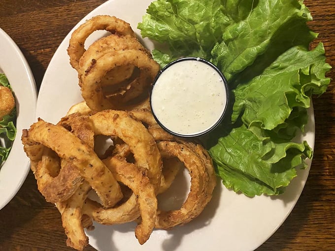 Onion rings that deserve their own zip code – golden, crispy halos served with ranch dressing and the promise of zero regrets.