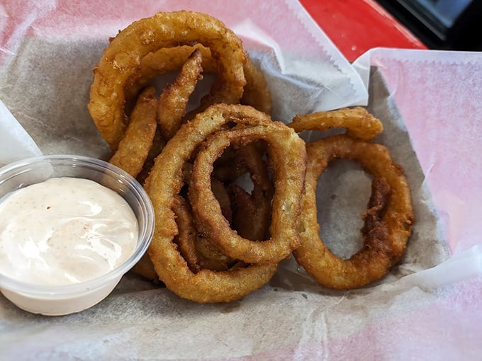 Golden-fried onion rings with that perfect crunch-to-tenderness ratio, served with a dipping sauce that makes you wonder why you'd eat vegetables any other way.