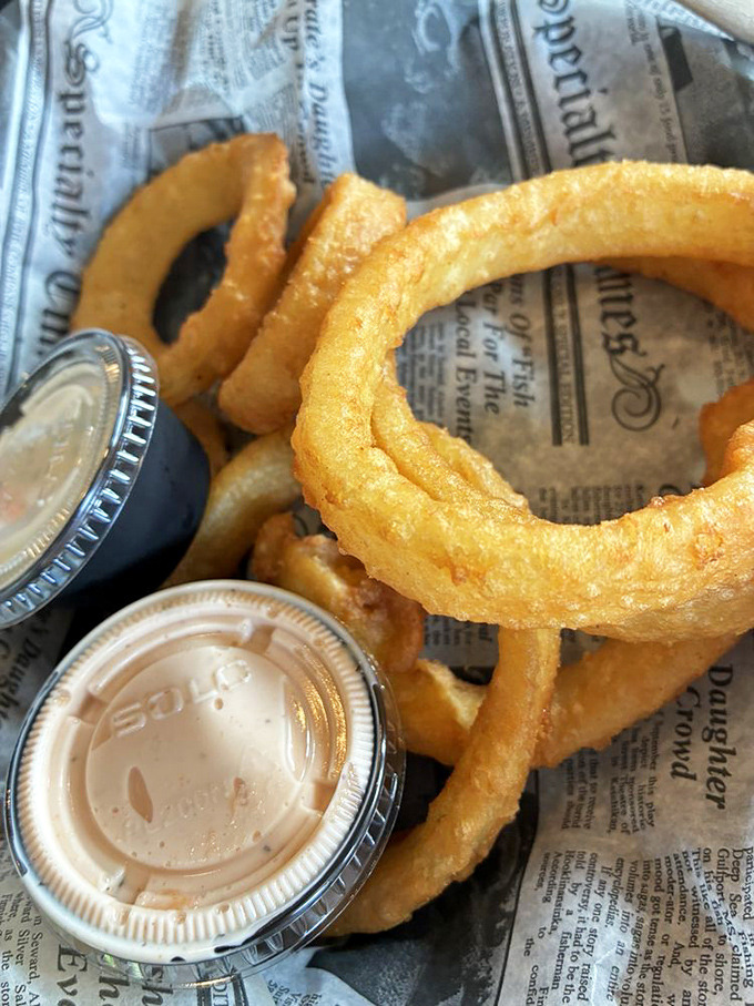 Onion rings so perfectly golden and substantial, they could double as Olympic medals for your taste buds. The dipping sauces are just showing off.