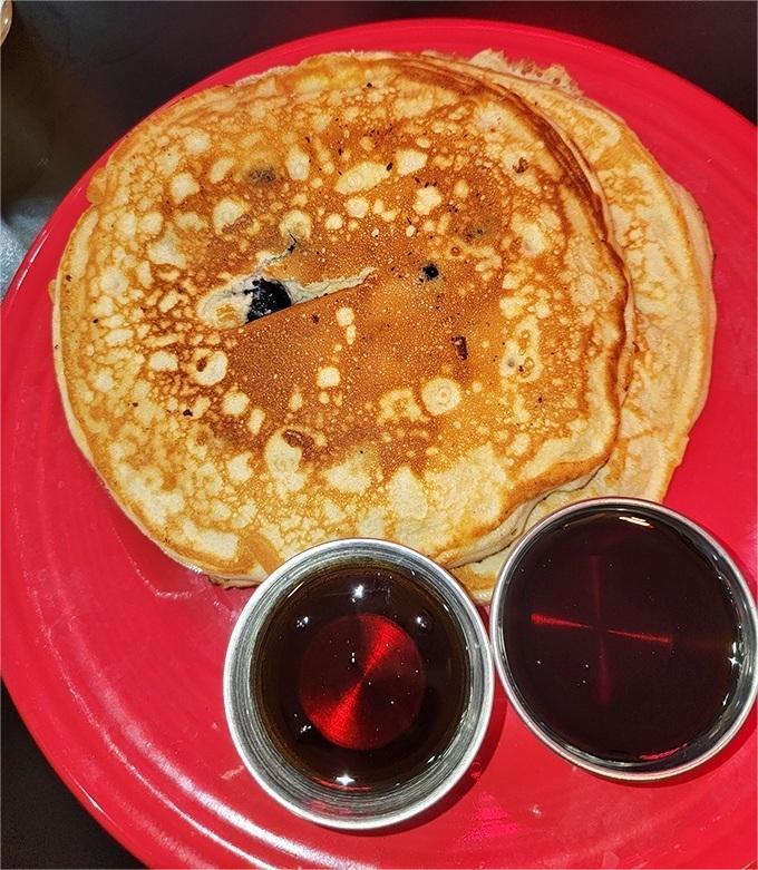 Pancake perfection doesn't need to be complicated. This golden disc with its lacy edges and twin syrup companions is breakfast simplicity at its finest.