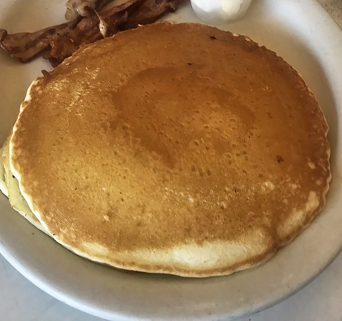 The pancake that launched a thousand satisfied sighs&mdash;golden, perfectly round, and just waiting for its maple syrup baptism.