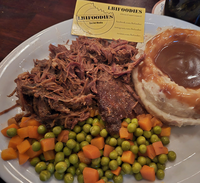 Pot roast so tender it practically surrenders to your fork, surrounded by the holy trinity of comfort food: carrots, peas, and potatoes.