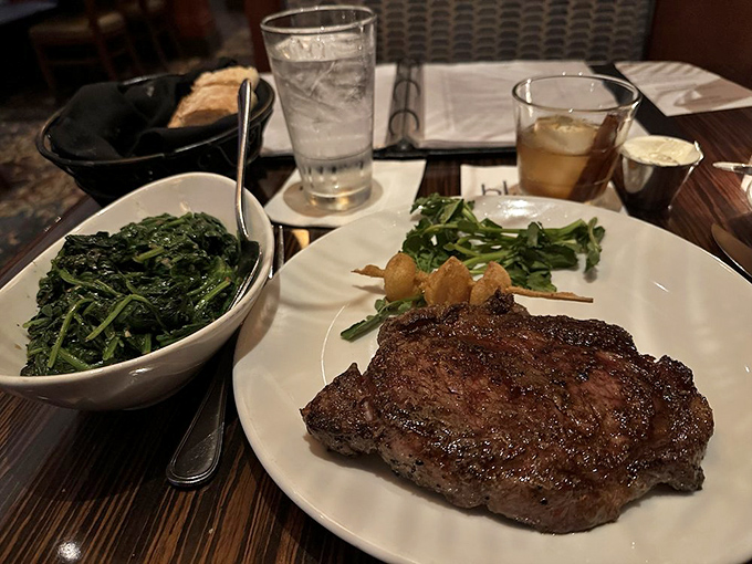Behold the star of the show: a perfectly seared ribeye alongside saut&eacute;ed spinach. This isn't just dinner&mdash;it's a religious experience.