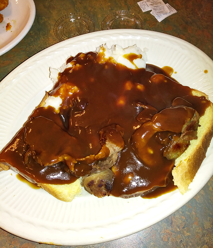 Open-faced roast beef sandwich swimming in gravy – the kind of meal that makes you want to take a nap afterward and regret nothing.
