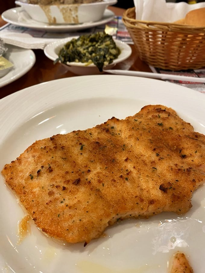Golden-brown and herb-crusted, this fish isn't just cooked—it's been treated with the respect seafood deserves. The side of greens adds color and virtue.