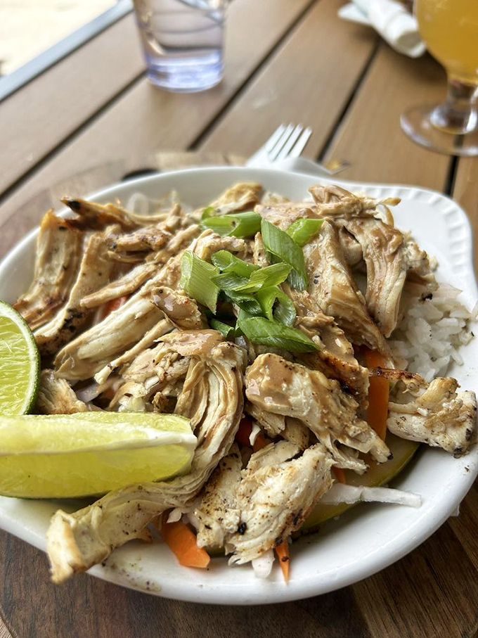 Not your grandmother's chicken and rice—tender pulled chicken atop fresh vegetables and rice, with a lime wedge standing by for that crucial acid balance.