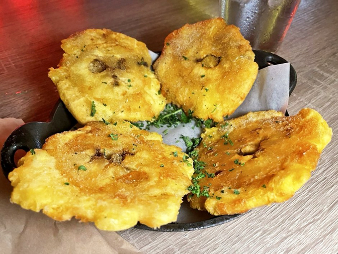 Golden tostones that crunch like nature's chips, served with a cilantro sauce that would make your abuela nod in approval—if not outright jealous.